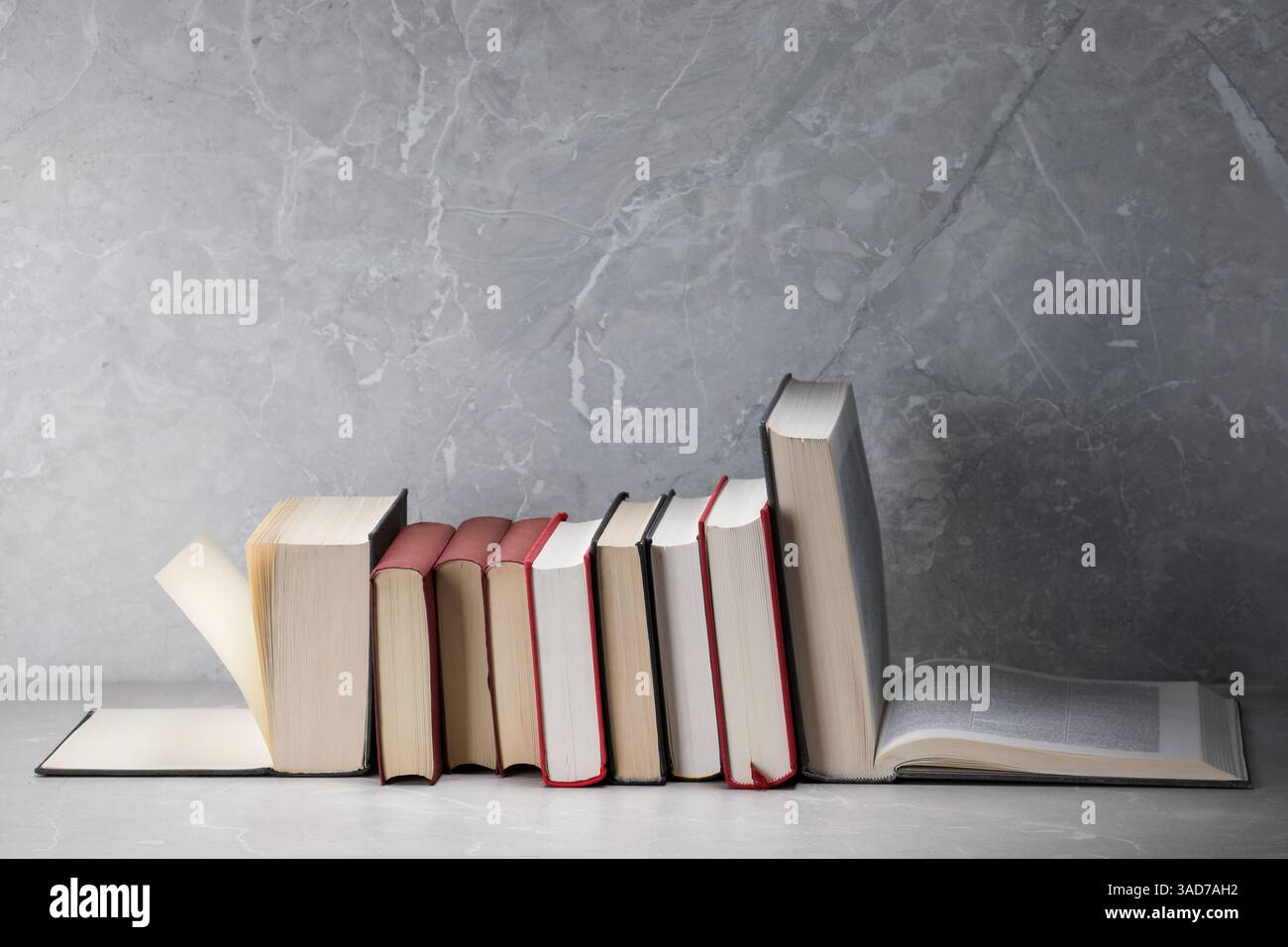 Different old books on light grey marble table Stock Photo - Alamy