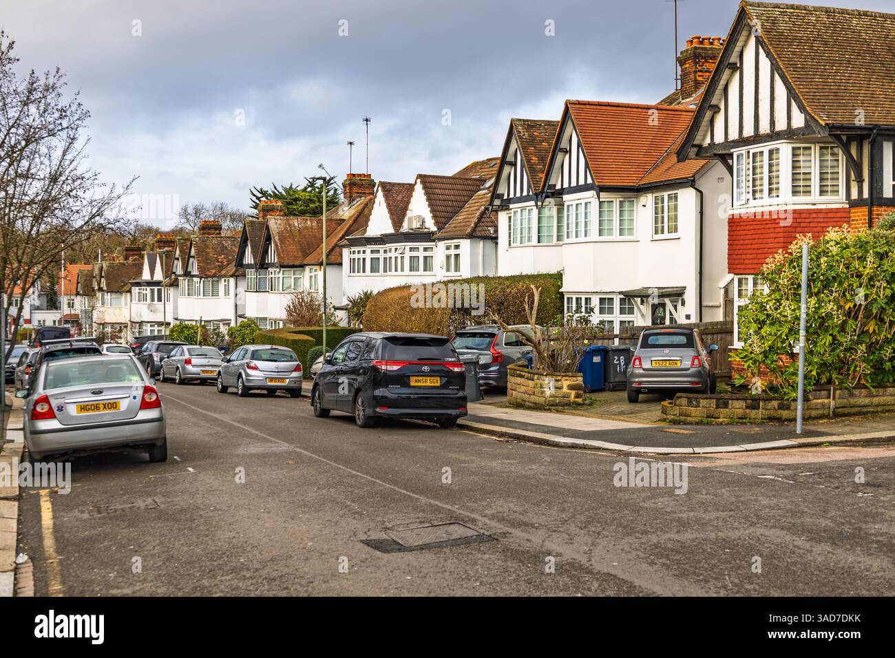 Traditional suburban English residential street with cars parked ...