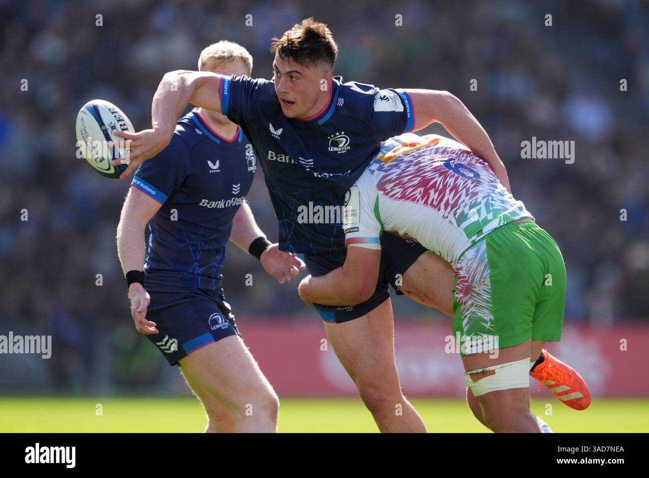 Leinster's Dan Sheehan (left) is tackled by Harlequins' Jack Kenningham ...