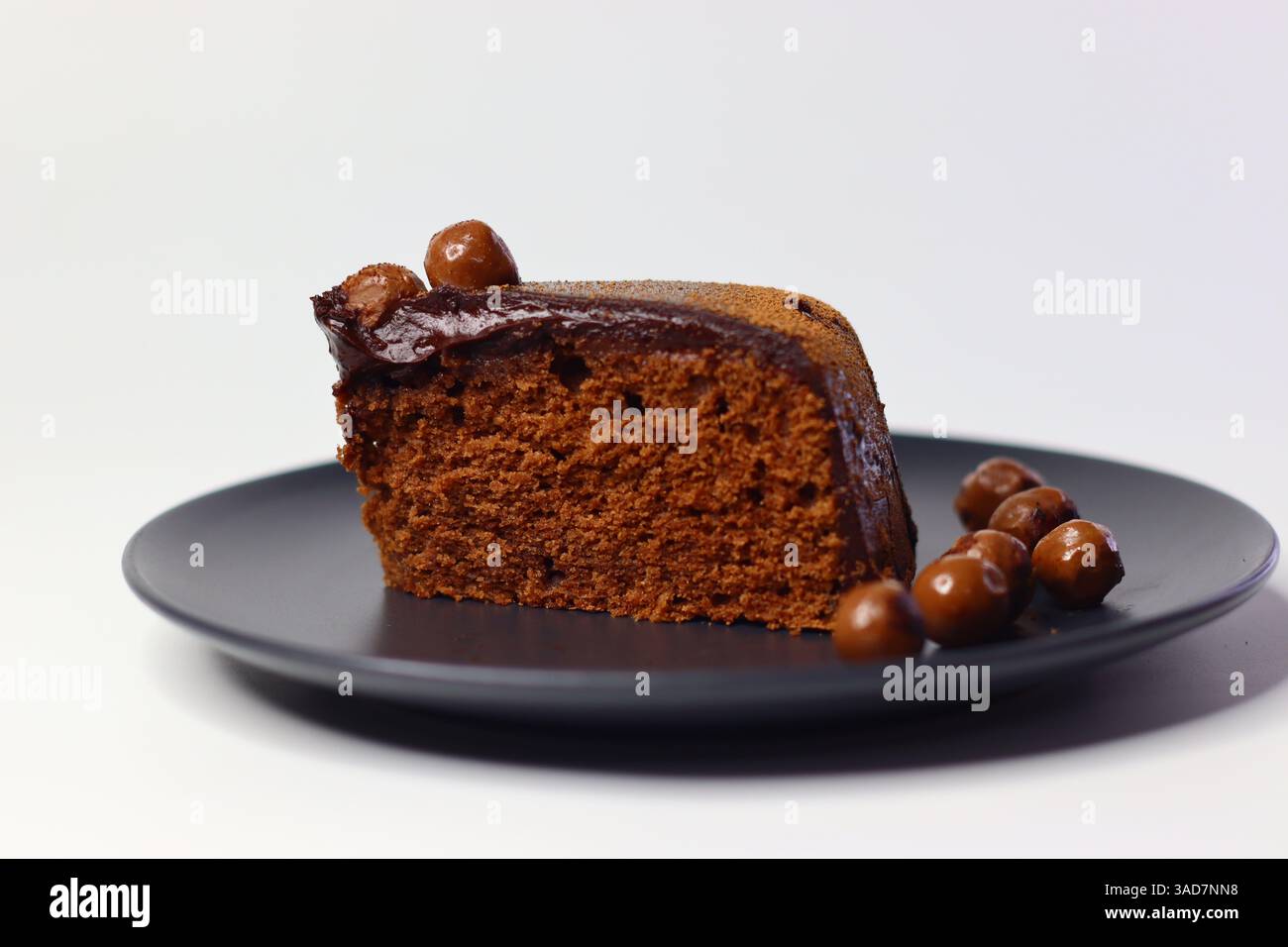 Rich, moist chocolate cake slice topped with glossy chocolate ganache ...