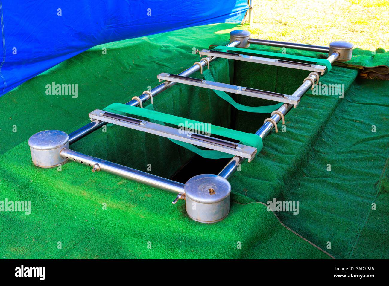 Silver holder for coffin is placed above freshly dug grave with silent ...