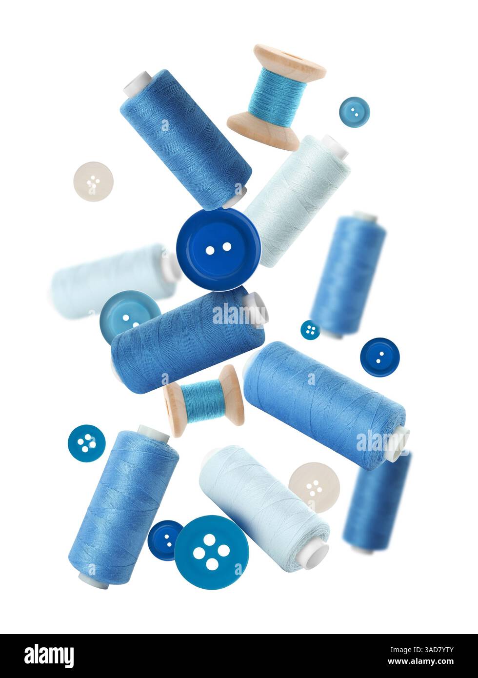 Many sewing threads in different shades of blue and buttons flying on ...