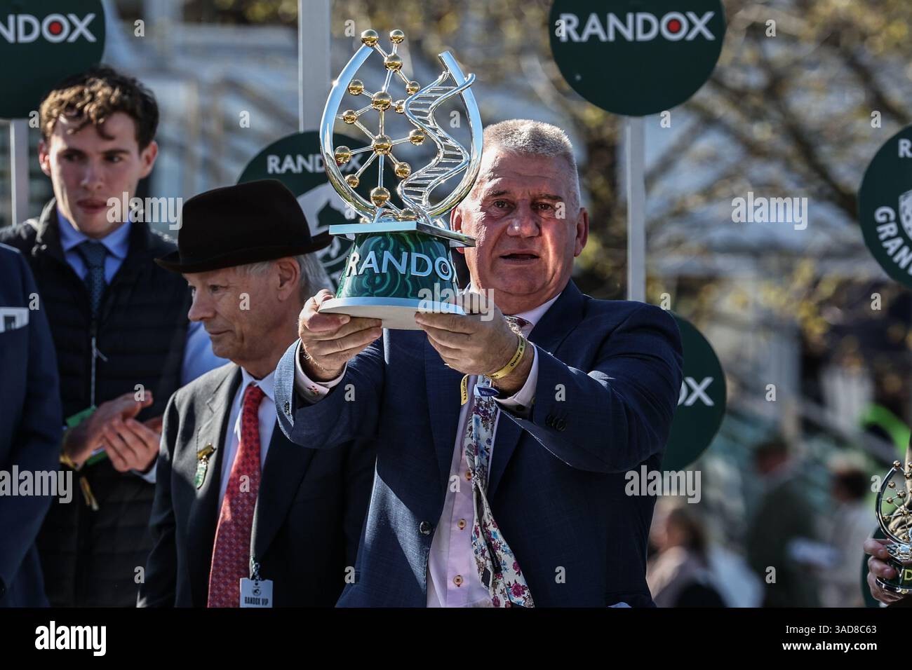 Stewart Andrew owner of Nick Rocket lifts the Grand National Trophy ...