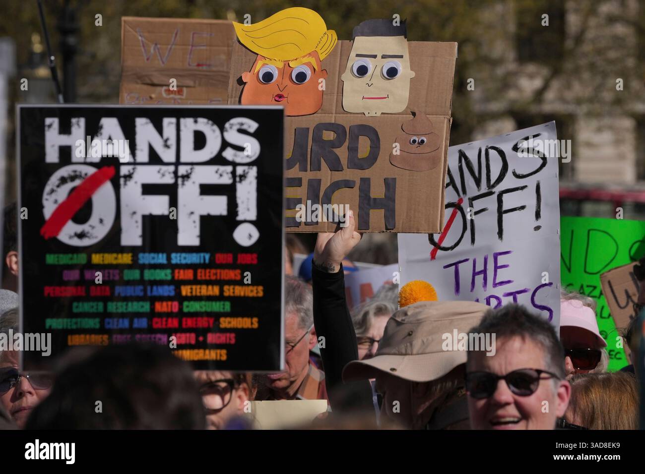Protesters hold signs as they join a "Hands Off!" demonstration against ...