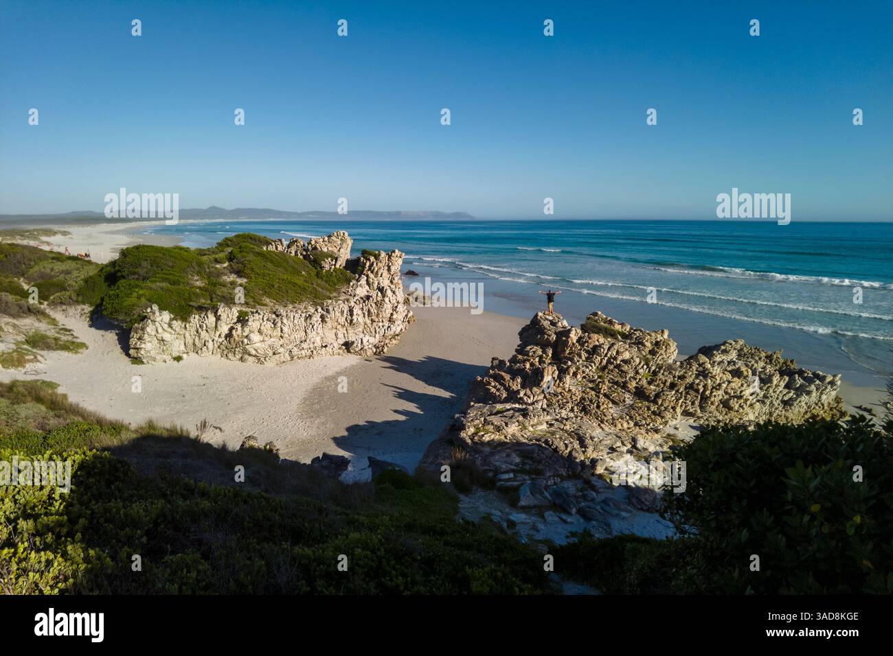 A tourist enjoying the glorious Hermanus coastline showing Grotto Beach ...
