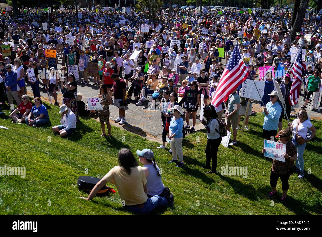 Protesters carry signs in protest to the policies of President Donald ...