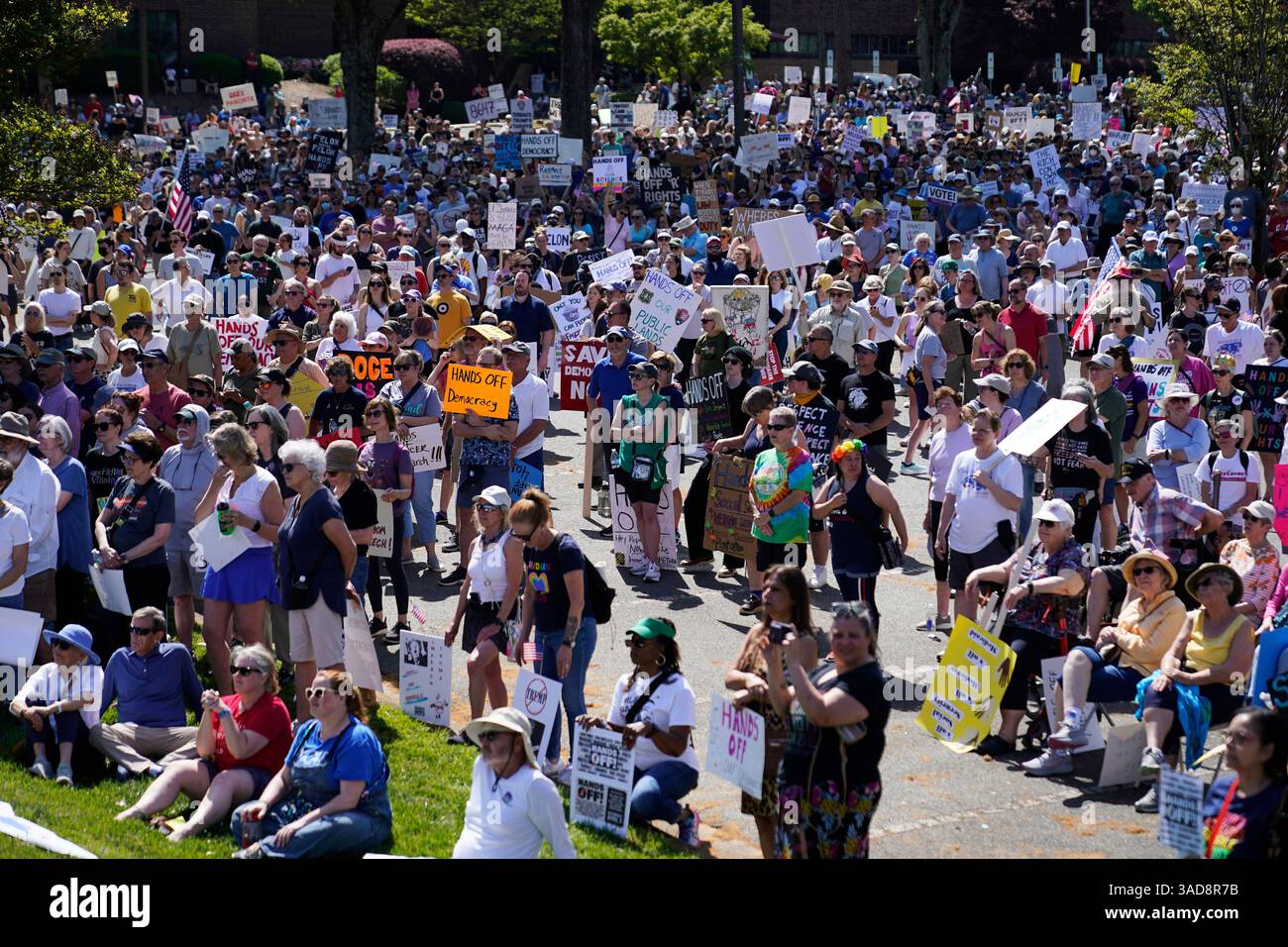 Protesters carry signs in protest to the policies of President Donald ...