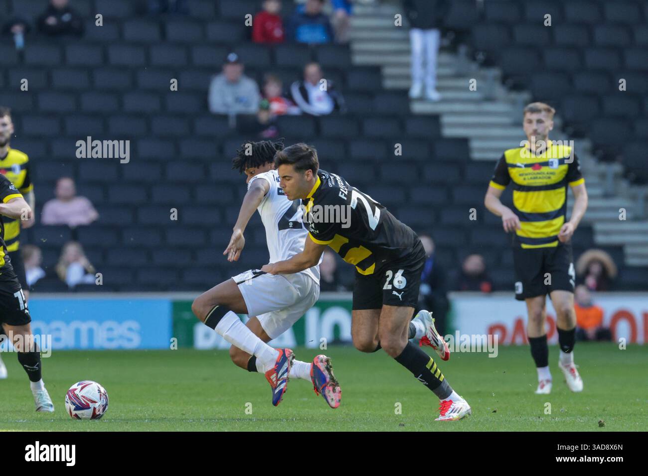 MK Dons Kane Thompson-Sommers is challenged by Barrow's Isaac Fletcher ...