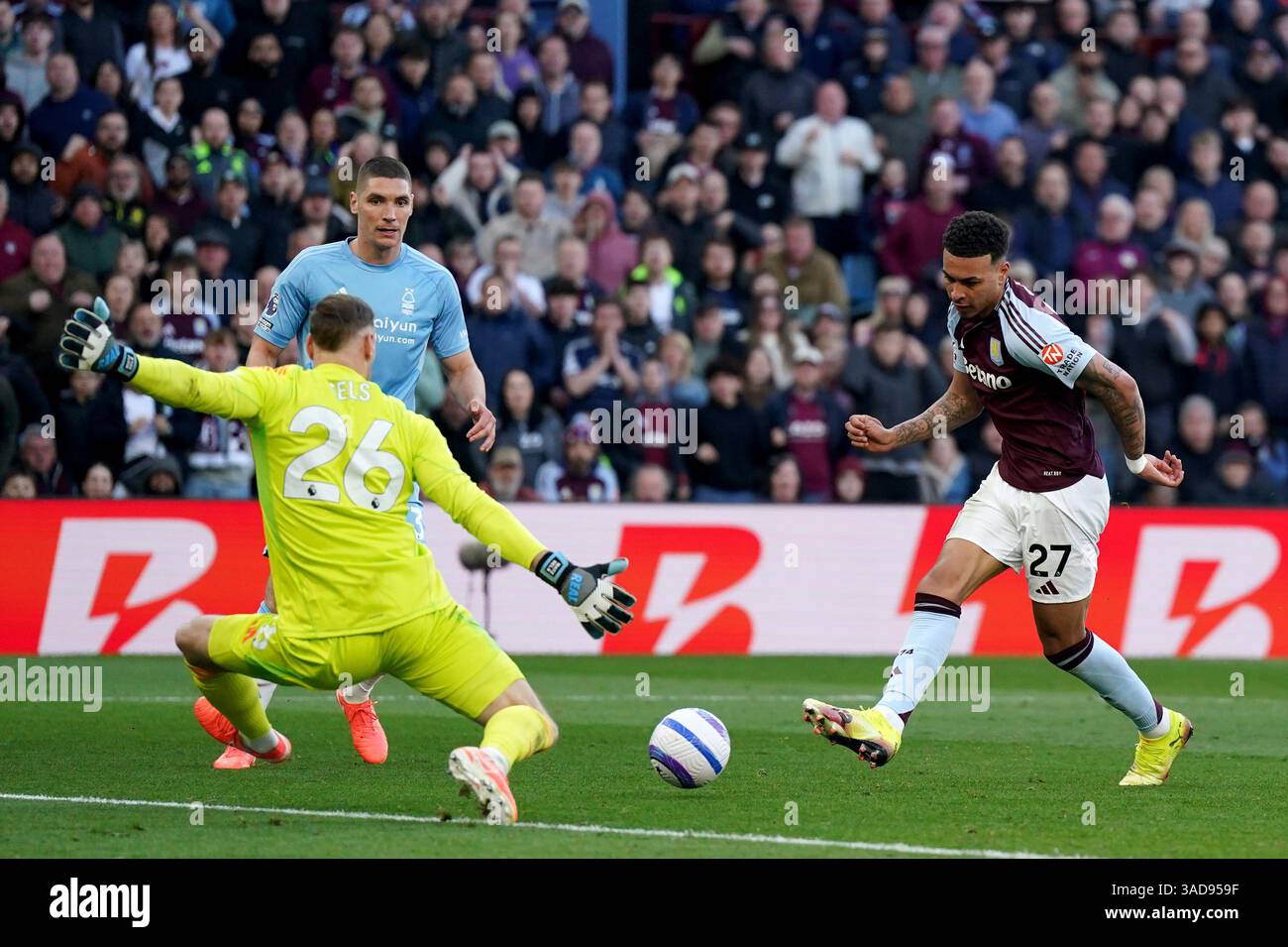 Aston Villa's Morgan Rogers (right) has a shot saved by Nottingham ...