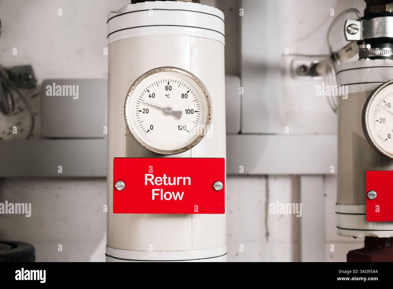Temperature gauge on return flow pipe of heating system in building ...