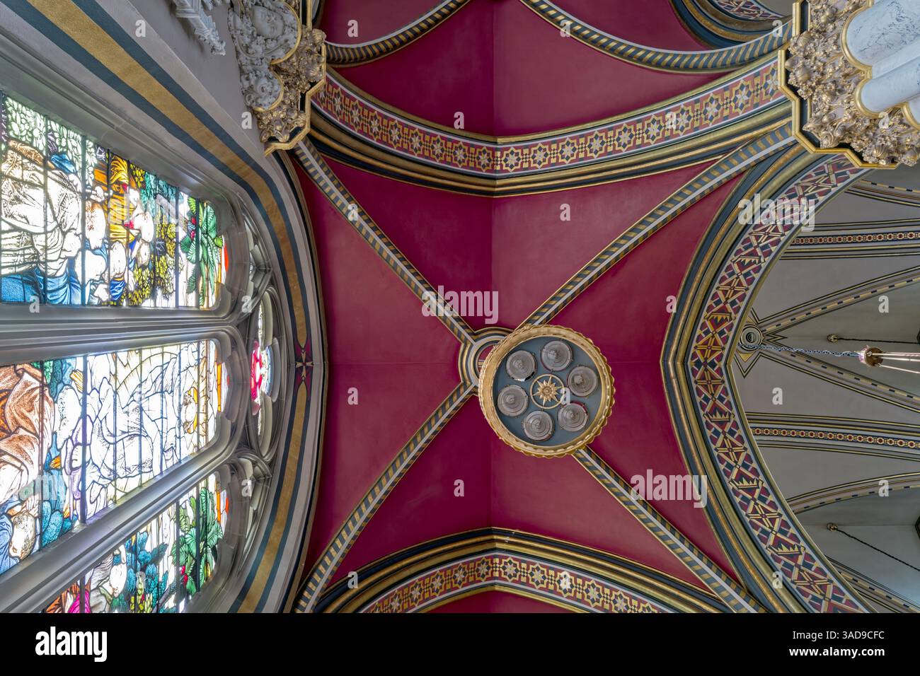 Upward view of stained glass windows and a chandelier in the Cathedral ...