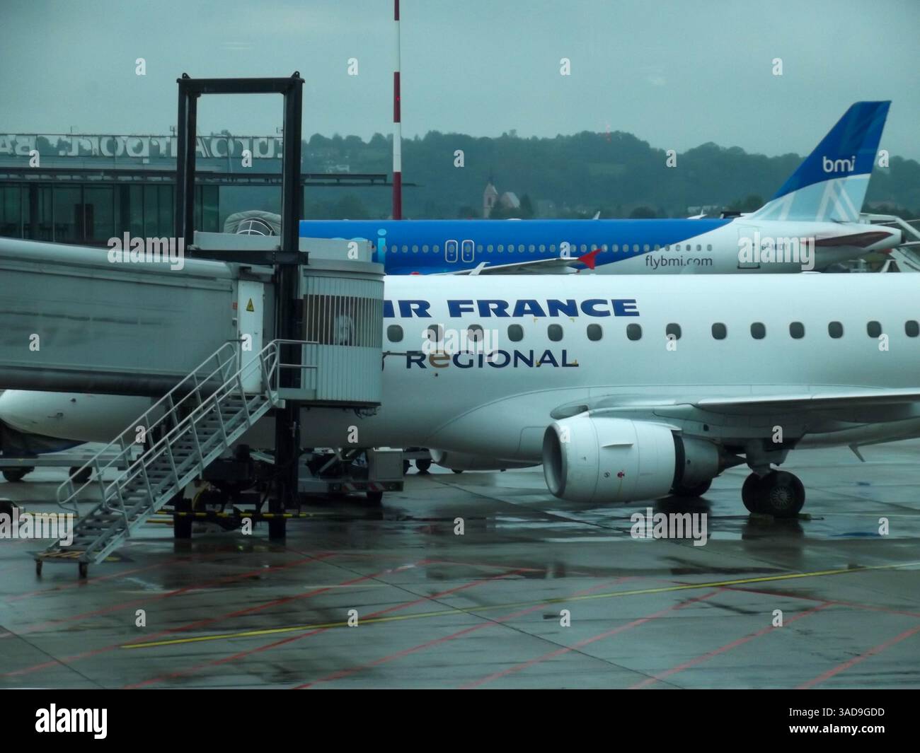 An Air France Regional aircraft parked at an airport gate, with a jet ...