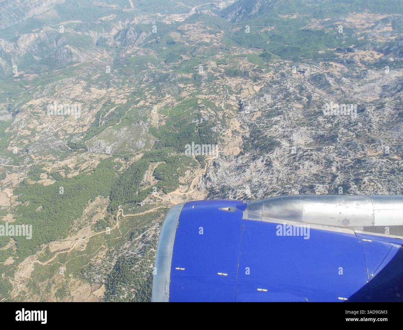 Aerial view from an airplane showing a mix of rocky terrain and green ...