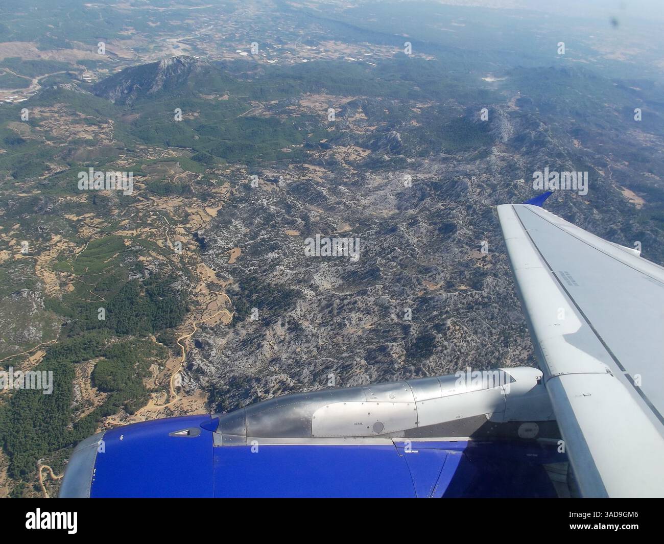Aerial view from an airplane showing mountainous terrain with patches ...