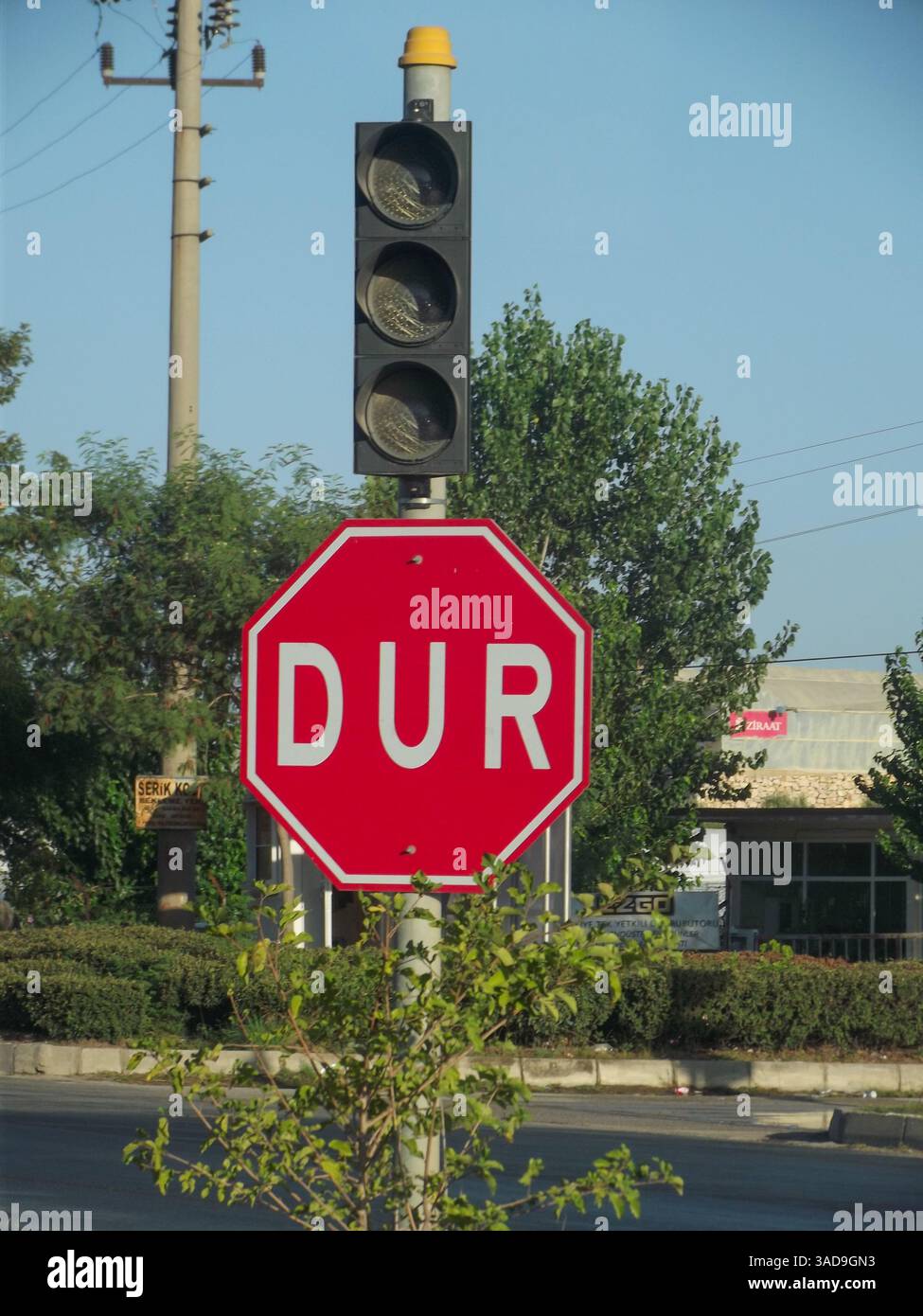 A red stop sign with the word 'DUR' in white letters, mounted on a pole ...