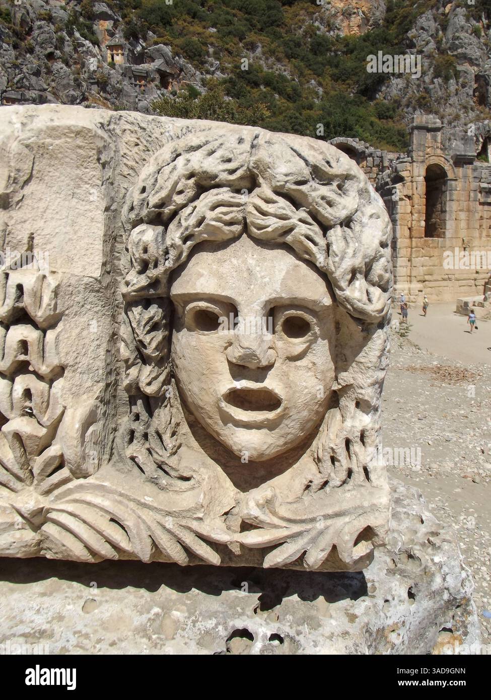 A close-up of an ancient stone carving depicting a face with intricate ...