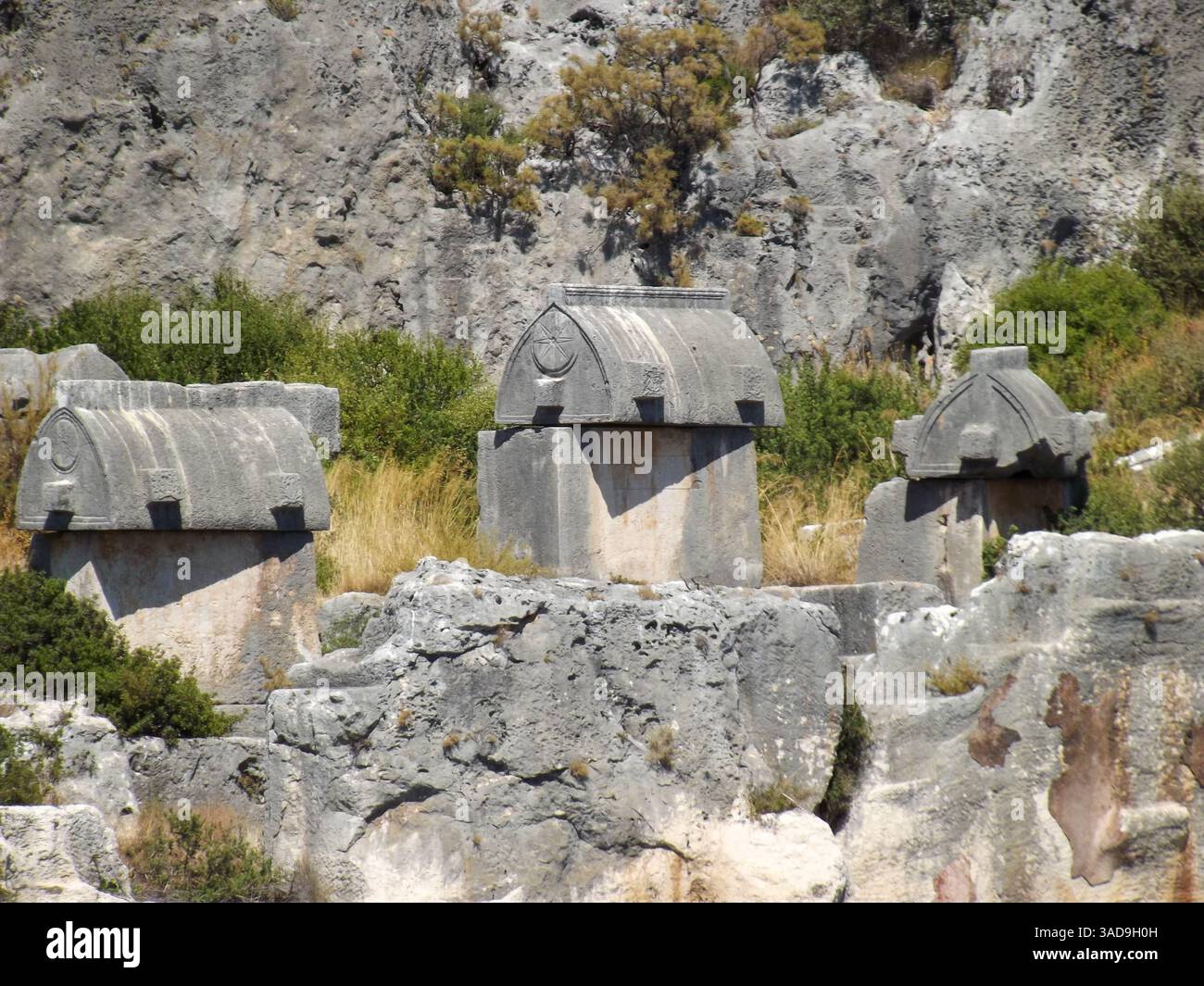 Ancient stone tombs with unique roof designs, nestled among rocky ...