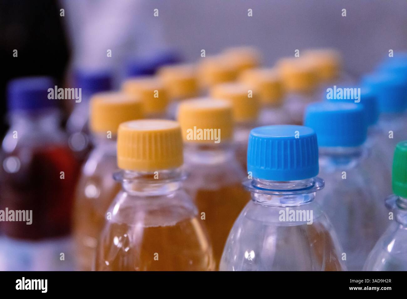 Many blue, yellow, green drinking water and refreshment beverage bottle ...