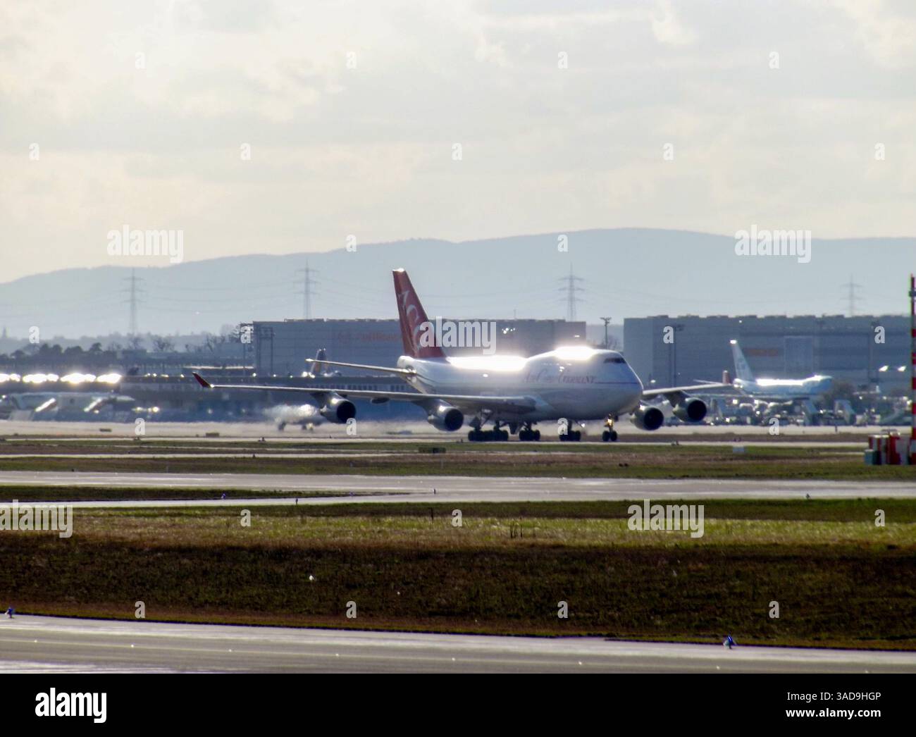 A large airplane, possibly a Boeing 747, taxiing on an airport runway ...