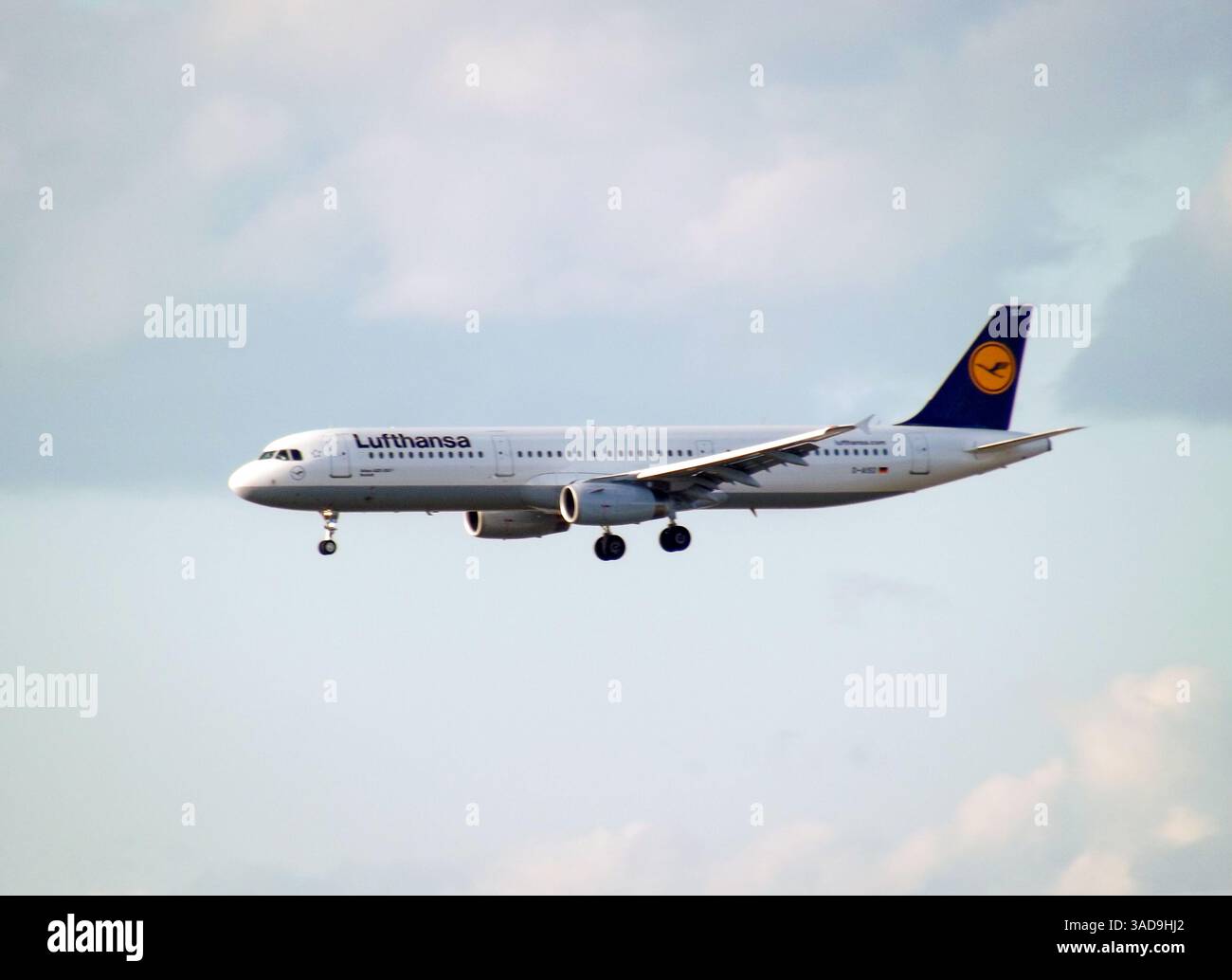 A Lufthansa airplane flying in the sky, approaching for landing. The ...