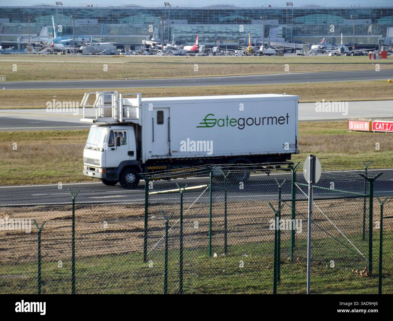 A delivery truck from Gate Gourmet driving on an airport runway, with ...