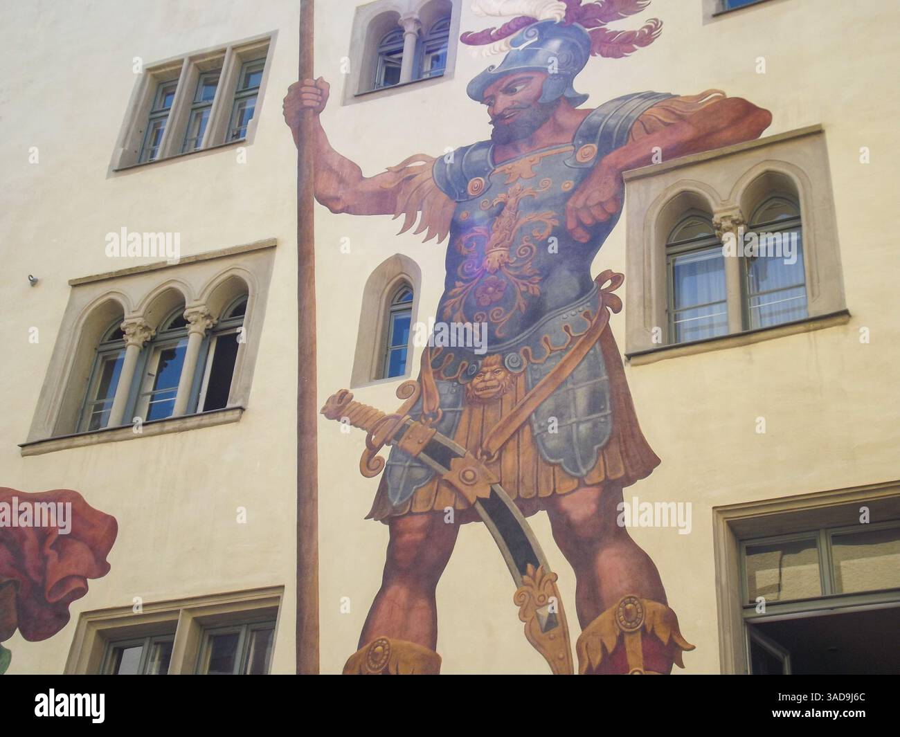 A large mural depicting a Roman soldier in armor, standing with a spear ...