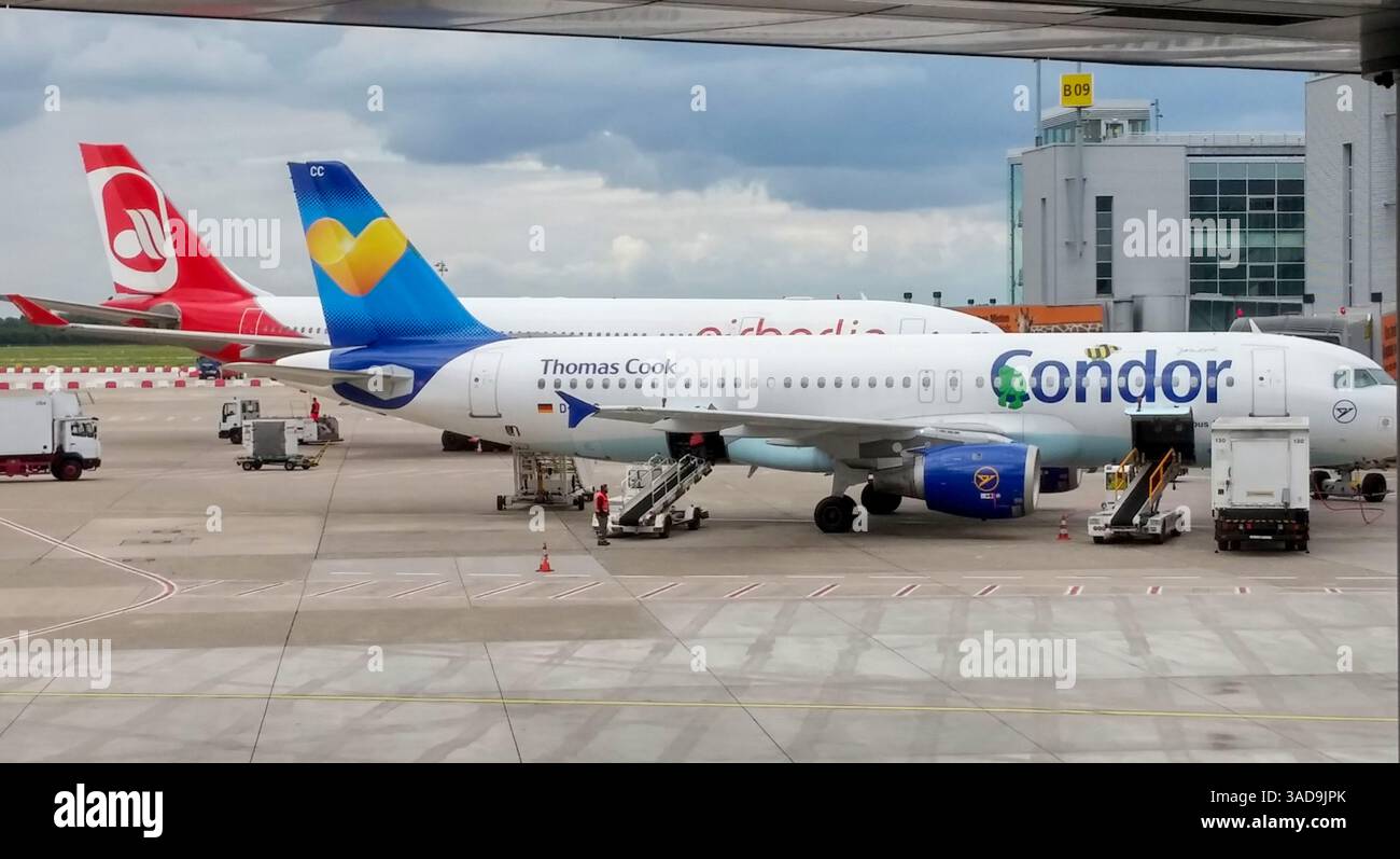 Two airplanes parked at an airport. One is a Condor aircraft with a ...