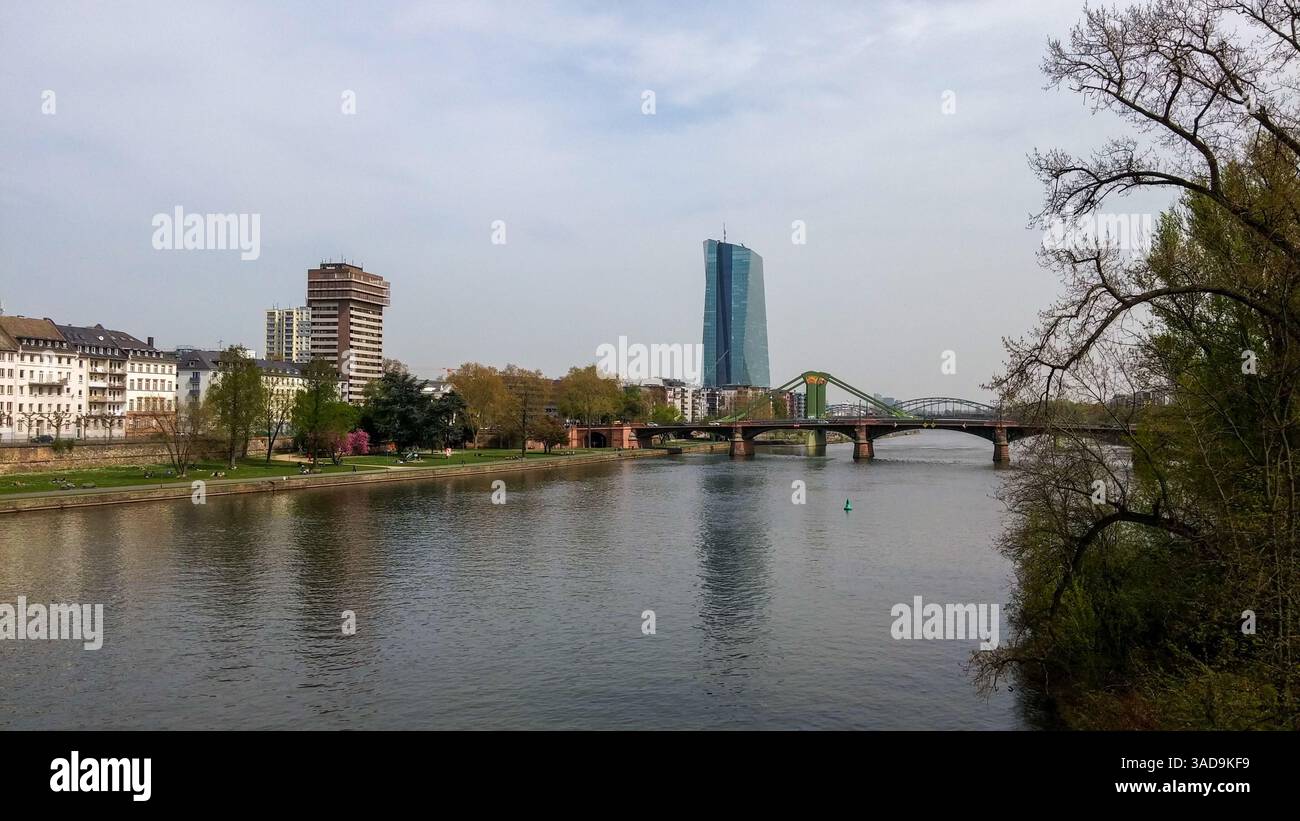 A scenic view of a river with modern buildings and a bridge in the ...