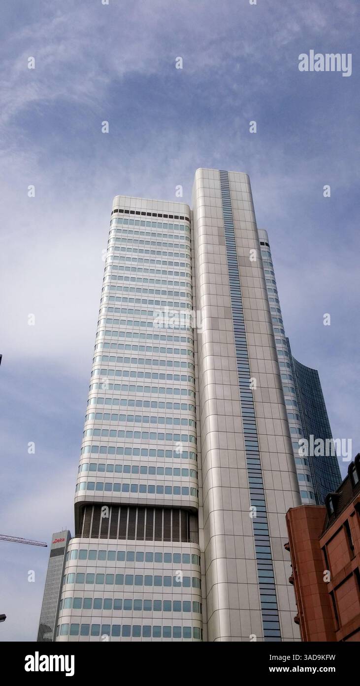 A tall modern skyscraper with a sleek glass and metal facade ...