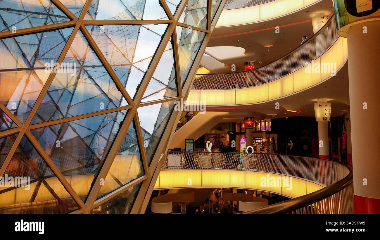A modern shopping mall interior featuring a geometric glass structure ...