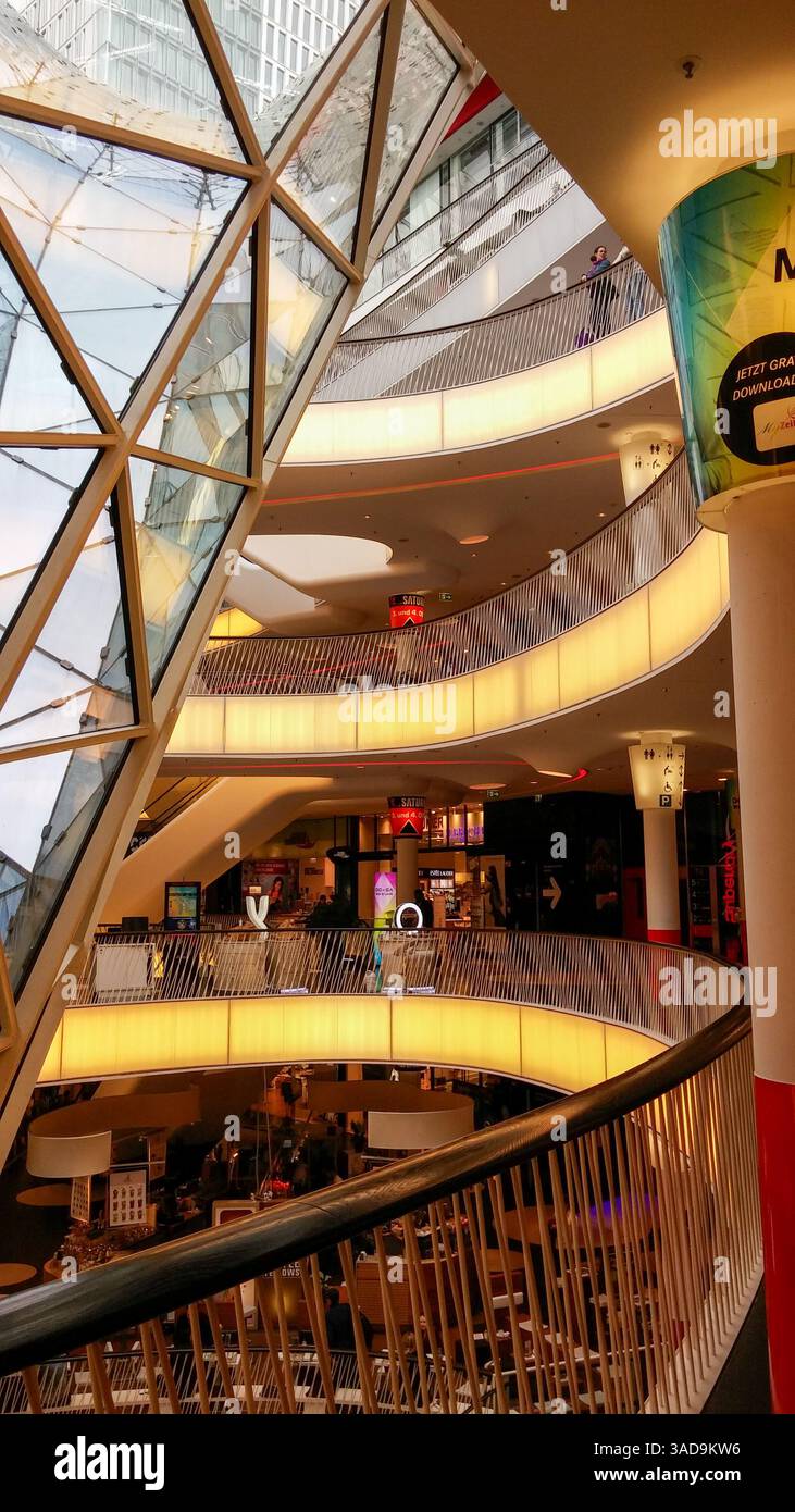 A modern shopping mall interior featuring a spiral staircase with ...