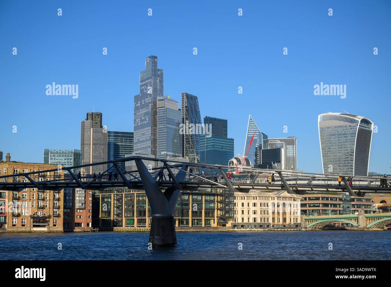 The Millennium footbridge over the River Thames with the skyscrapers of ...