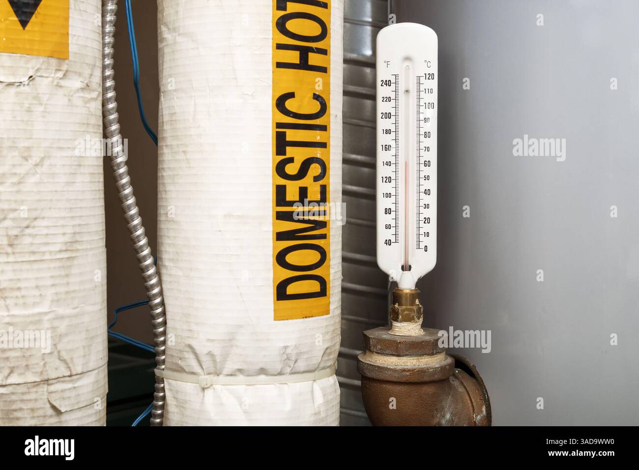 Thermometer on hot water tank in boiler room of building. Temperature ...