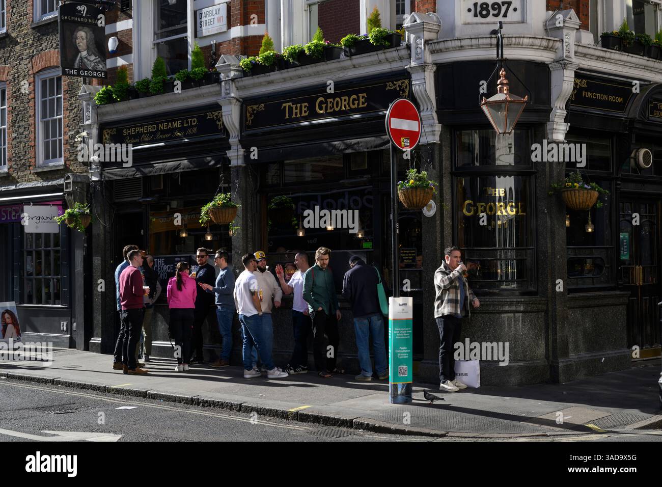 People drinking outside The George pub, D'Arblay Street, Soho, London ...