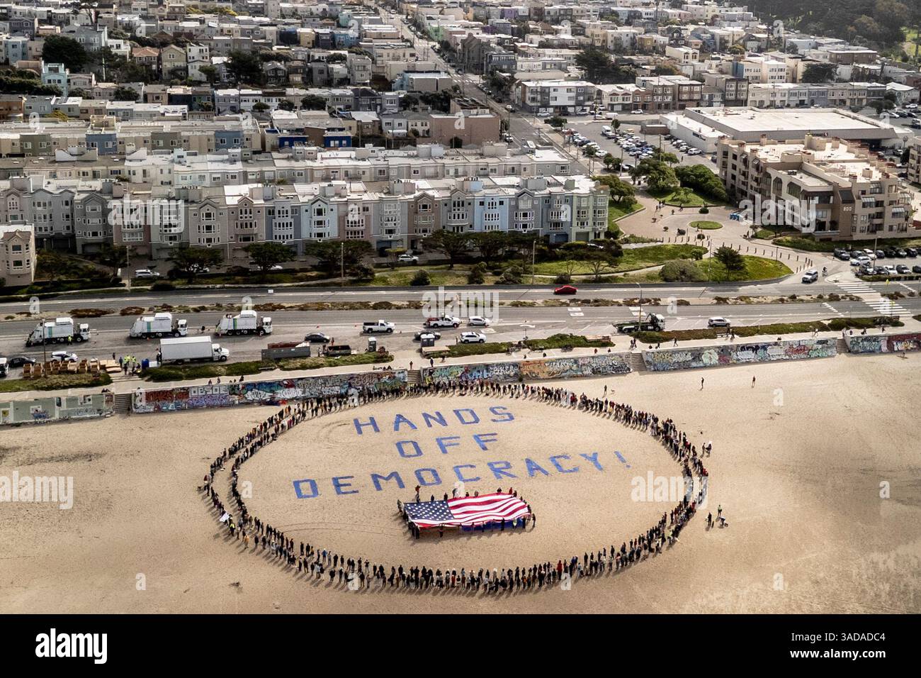Protesters form a human banner on Ocean Beach during a protest against ...
