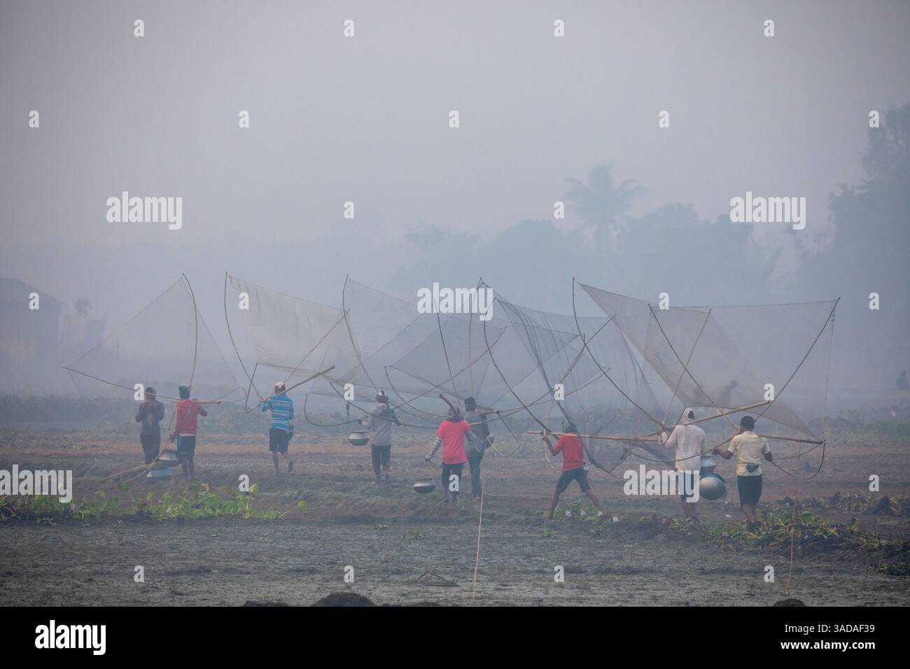 Fishermen make their way to Dikshir Beel on a foggy winter morning to ...