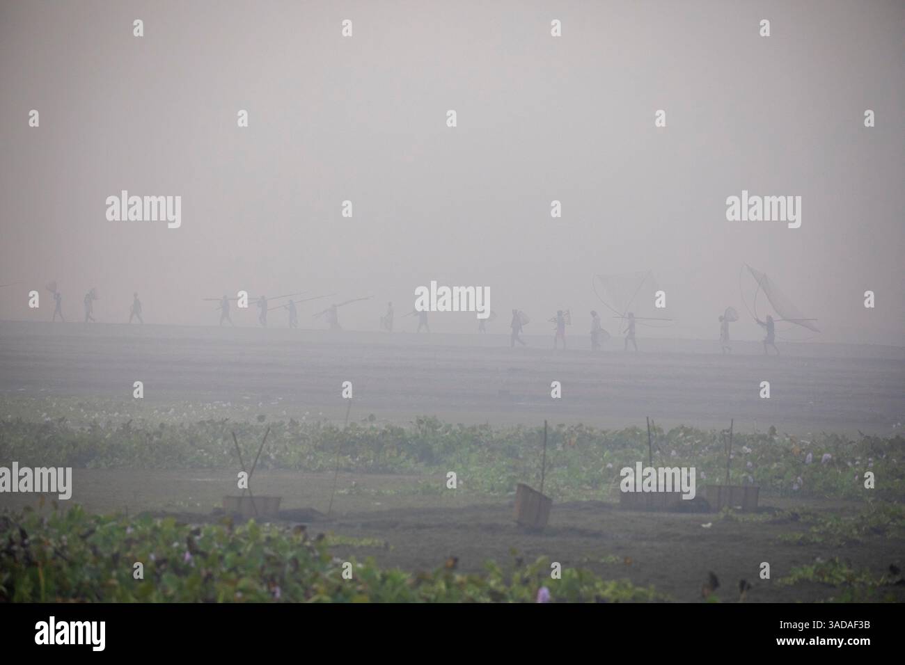 Fishermen make their way to Dikshir Beel on a foggy winter morning to ...