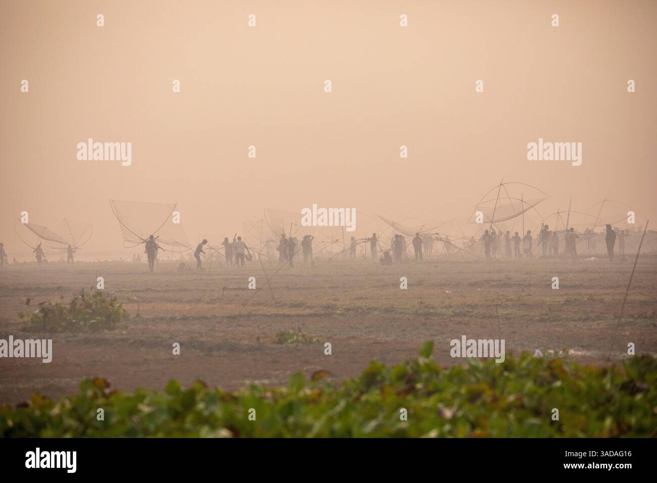 Fishermen make their way to Dikshir Beel on a foggy winter morning to ...