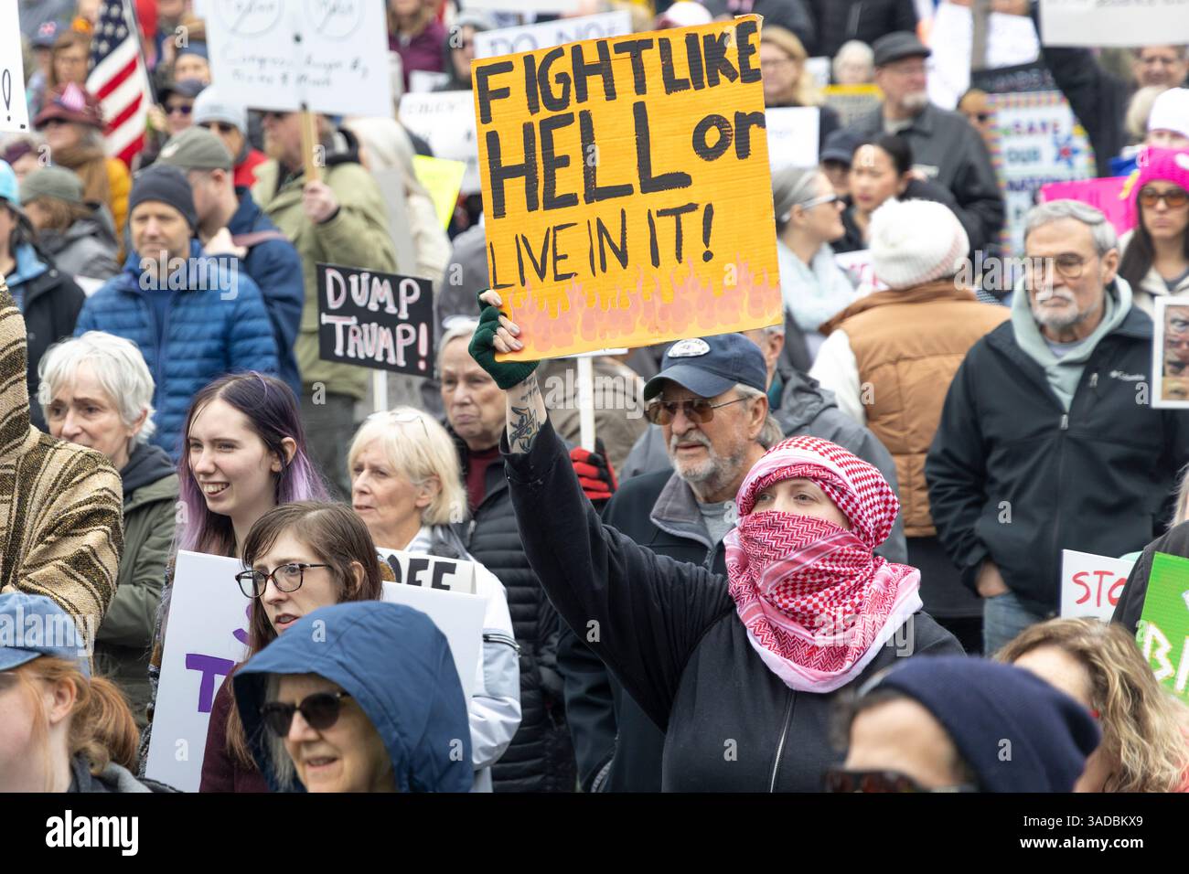 Bree Burns hoists a sign during a Hands Off! rally on Saturday, April 5 ...