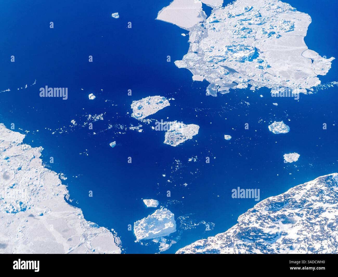 Aerial view of icy waters with floating icebergs and a deep blue ocean ...