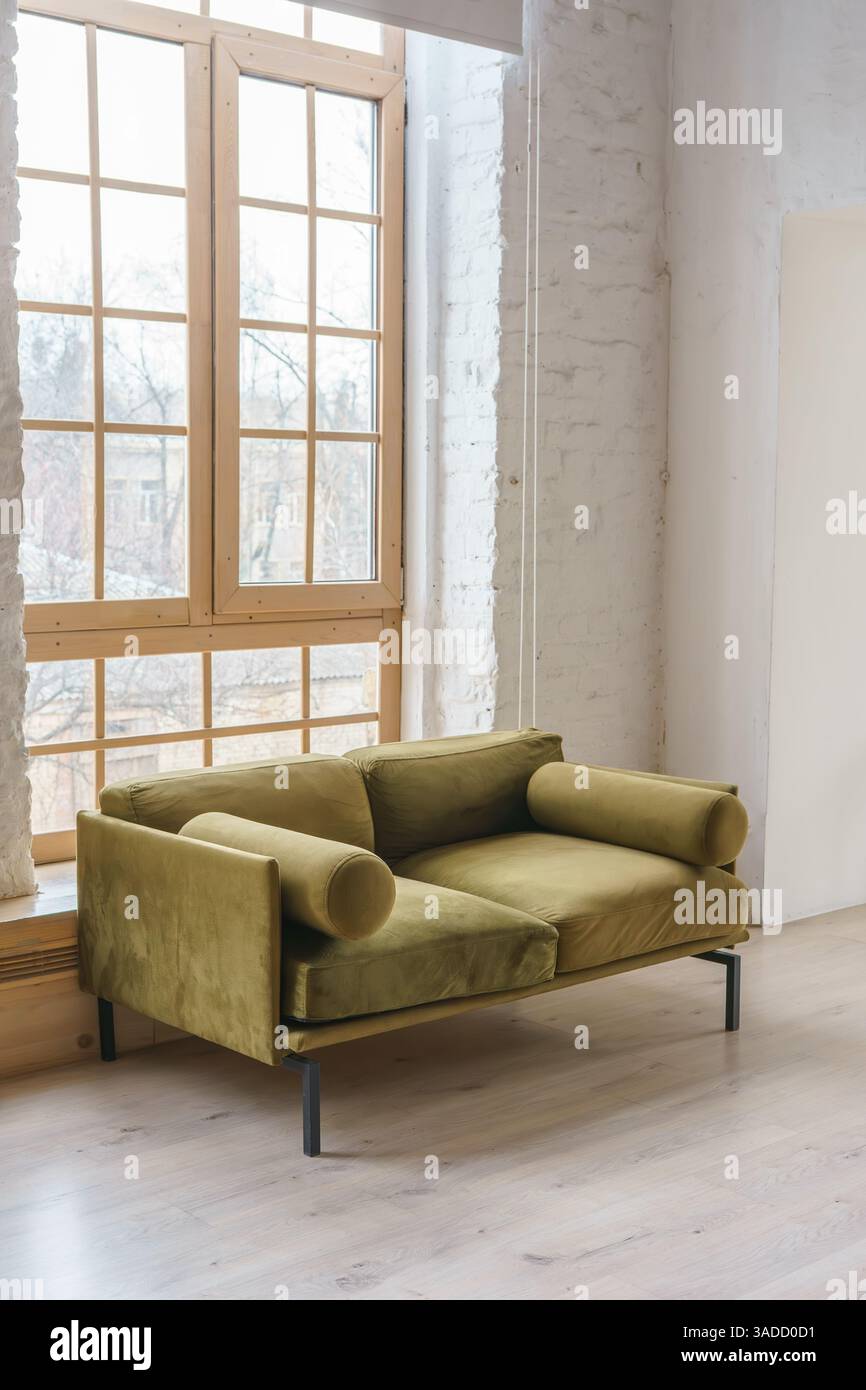 Cozy green khaki velours couch in bright and airy living space with ...