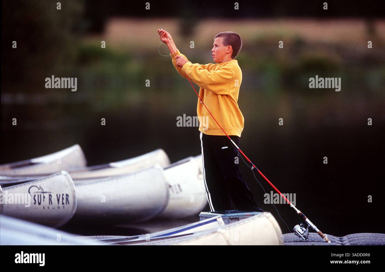 Aug 23, 2001; BEND, OR, USA; A boy readies his tackle for trout fishing ...