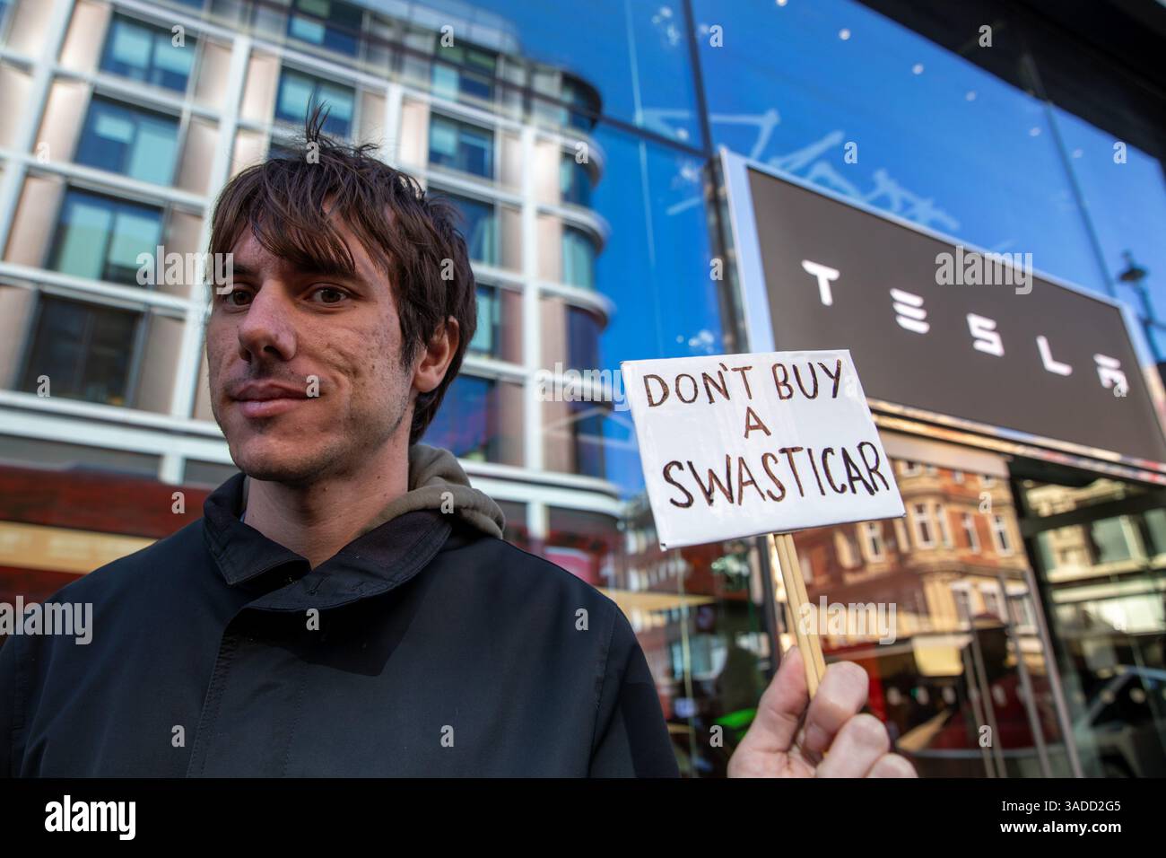 An activist holds a placard during an anti Tesla demonstration. A ...