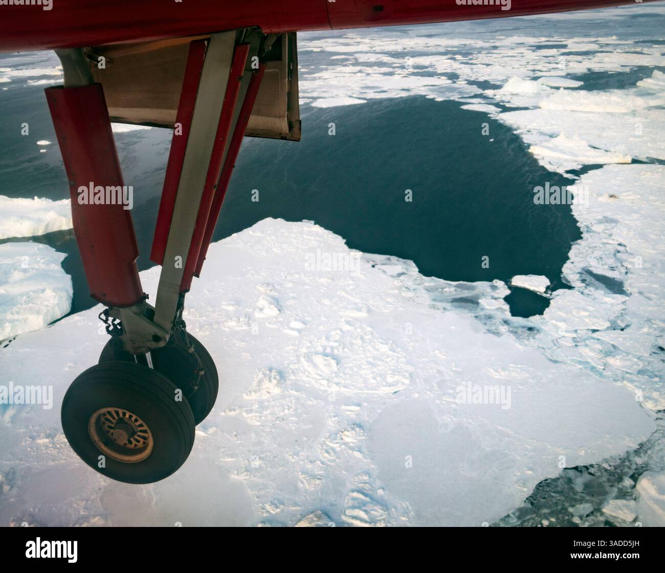 Aerial view of icebergs and frozen sea with an airplane's landing gear ...