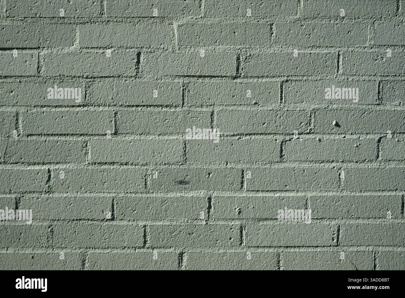 A smooth gray brick wall displays a uniform texture under natural light ...