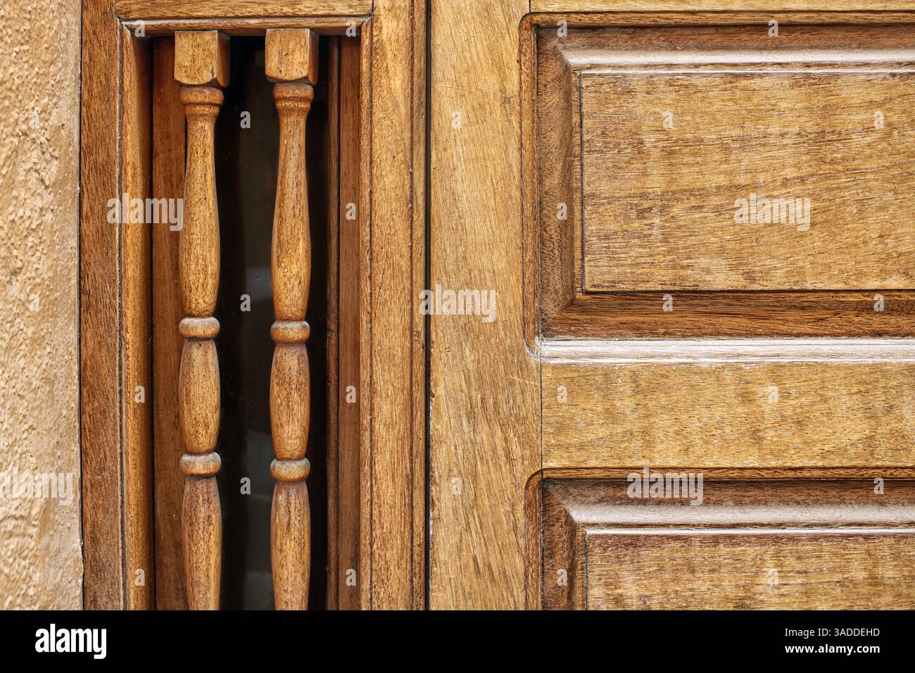 Close-up of a wooden entrance door with a window, decorative vertical ...