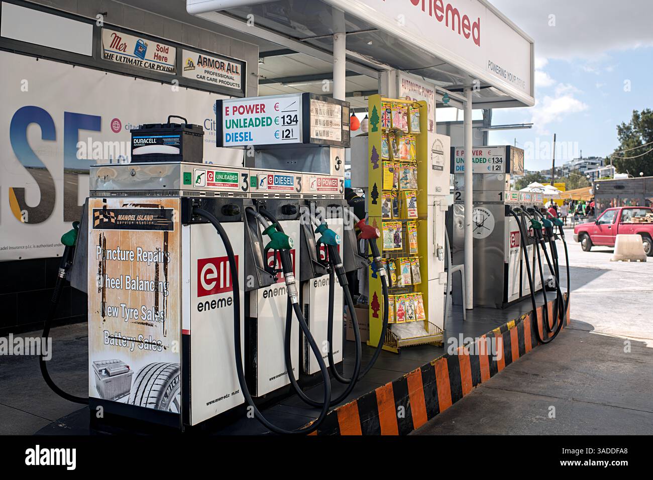 Street view of an Enemed gas station with fuel pumps, signage for ...