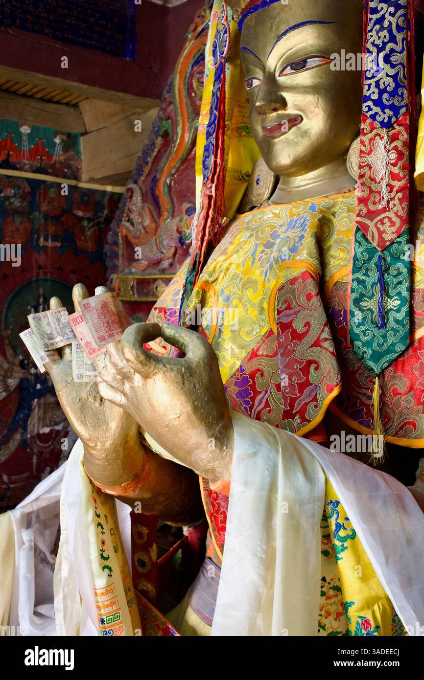 Maitreya Buddha statue adorned with silk brocade robes and ritual ...