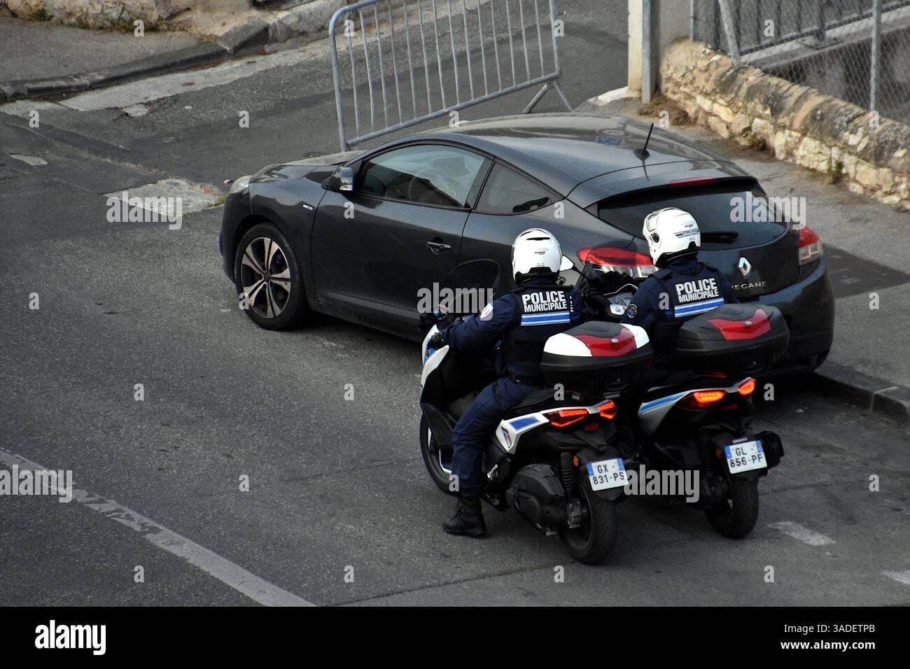 Two municipal police officers on their scooters ticket a vehicle for ...