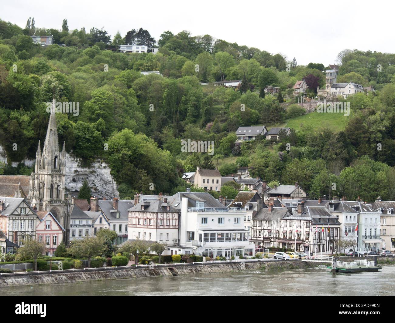 A village with a church and houses on a wooded hillside, Seine, France ...
